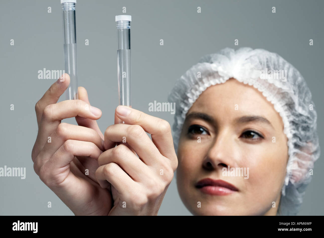 Lab female doctor looking at test tubes Stock Photo - Alamy