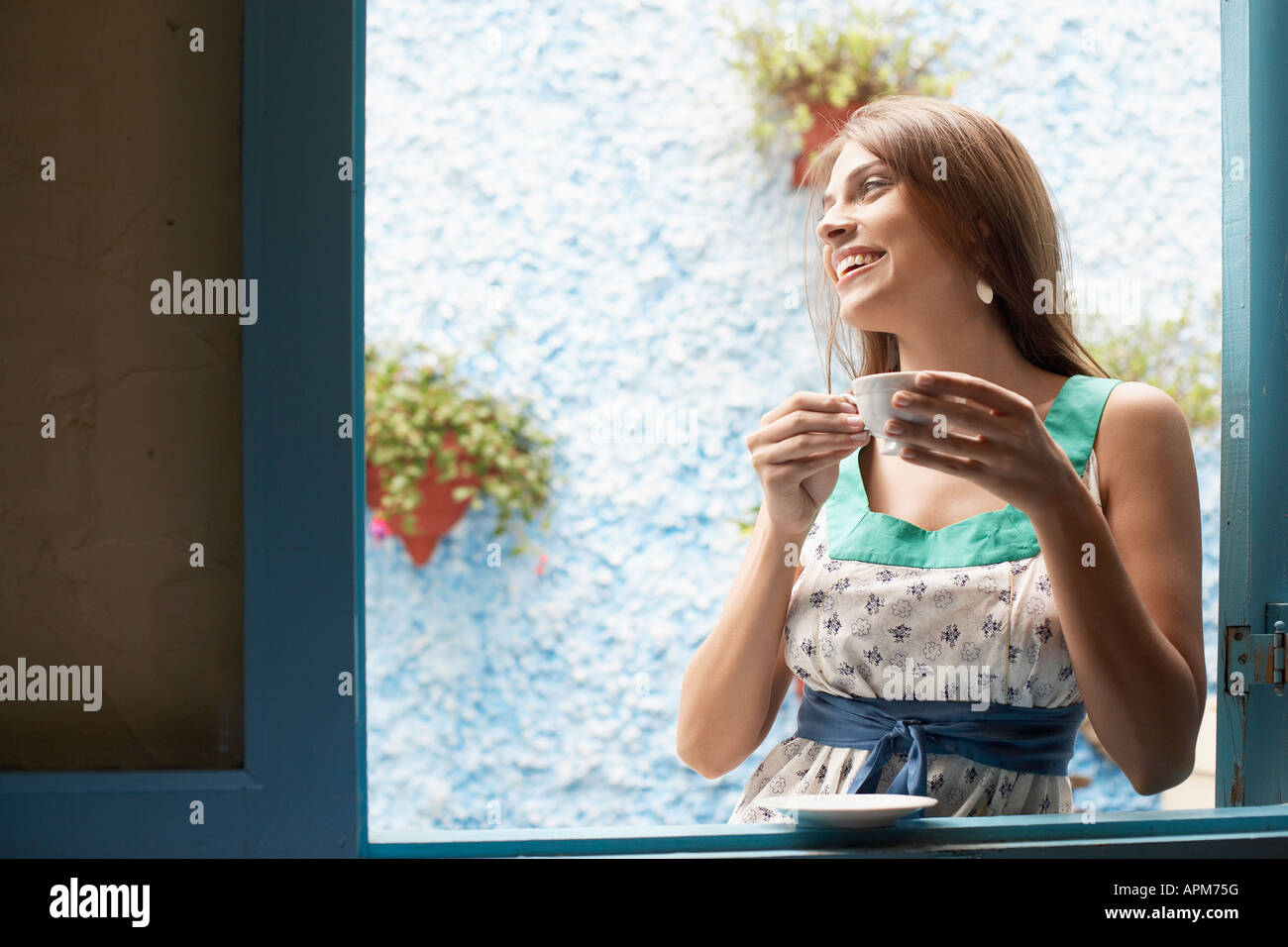 Woman drinking tea at window Stock Photo - Alamy