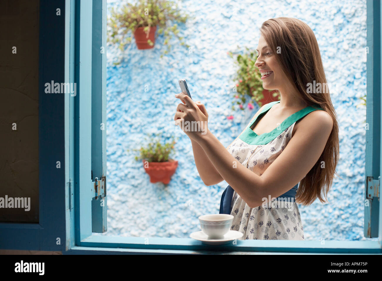 Woman text messaging by window Stock Photo - Alamy