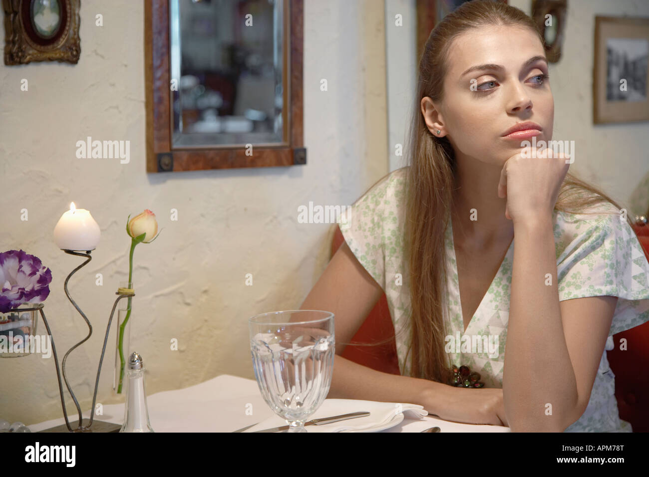 Bored woman sitting at dining table Stock Photo - Alamy