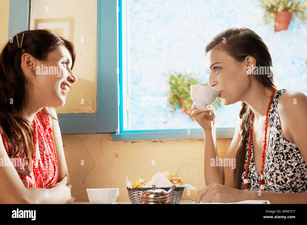 Two women talking at dining table Stock Photo - Alamy