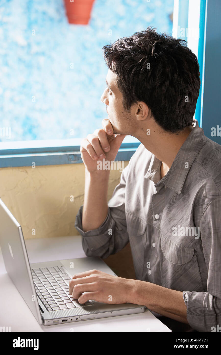 Man with computer looking through window Stock Photo - Alamy