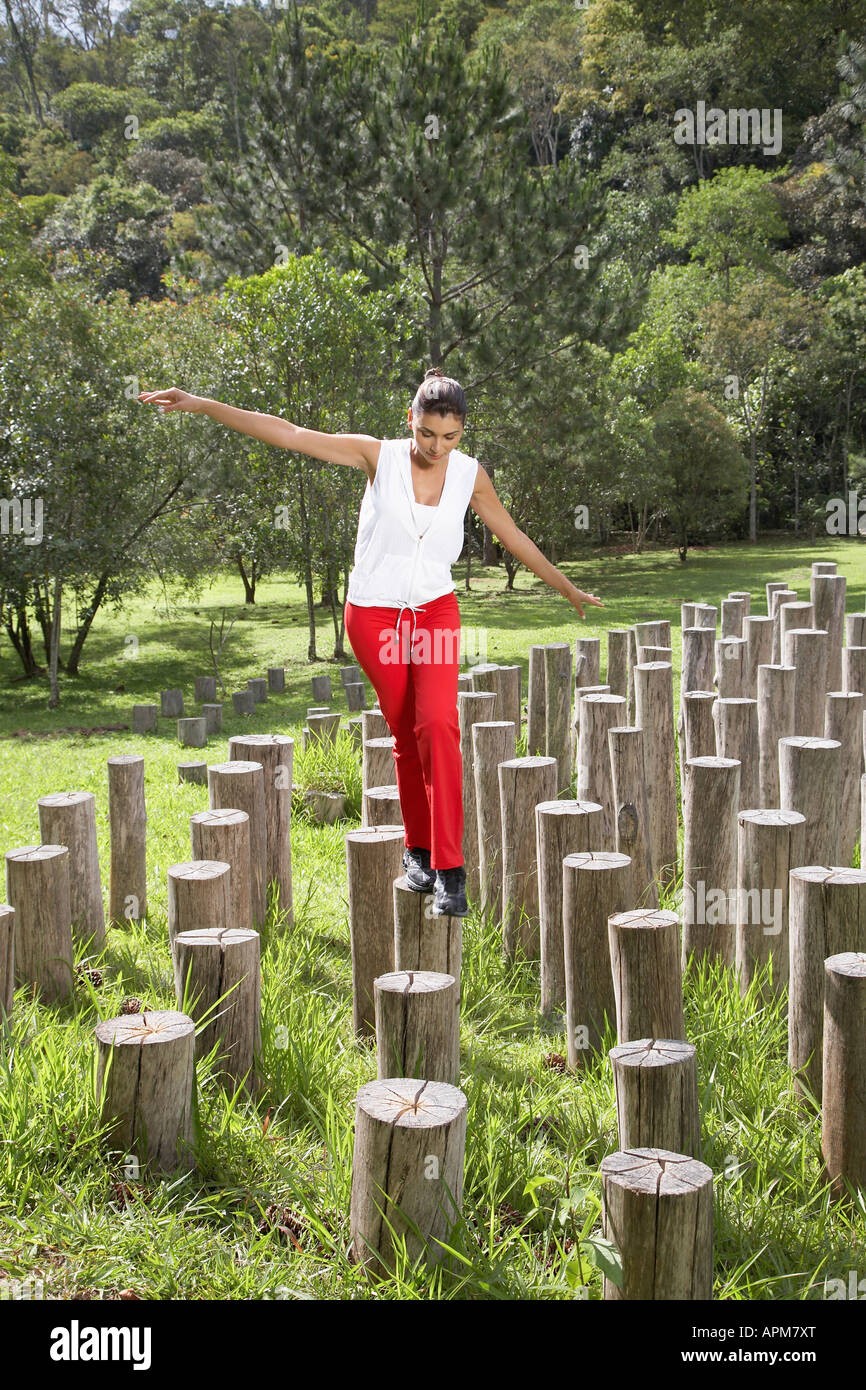 Young woman balancing on stumps Stock Photo - Alamy