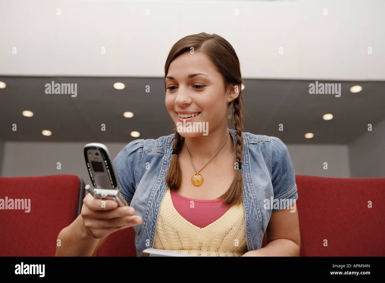 College student using cell phone in lecture theater Stock Photo - Alamy