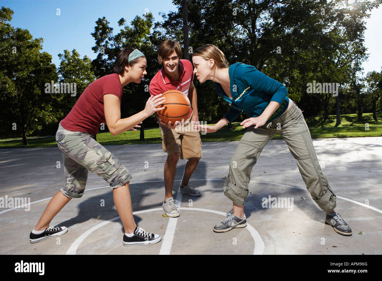 Three people playing basketball Stock Photo - Alamy