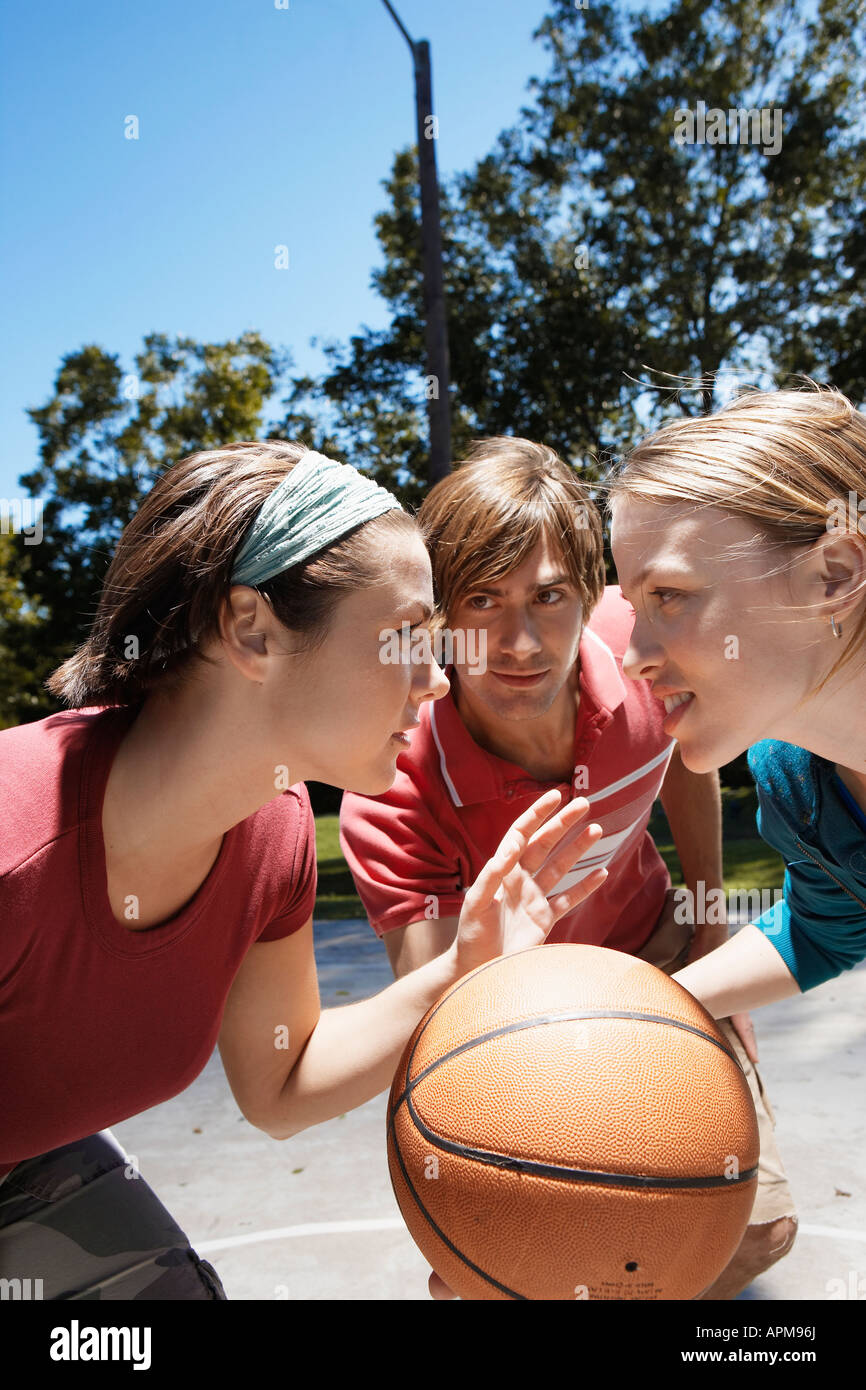 three people playing basketball Stock Photo - Alamy