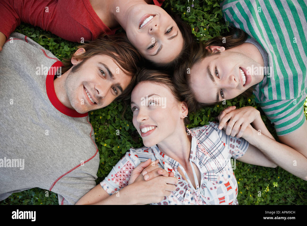 Four friends lying on grass hi-res stock photography and images - Alamy