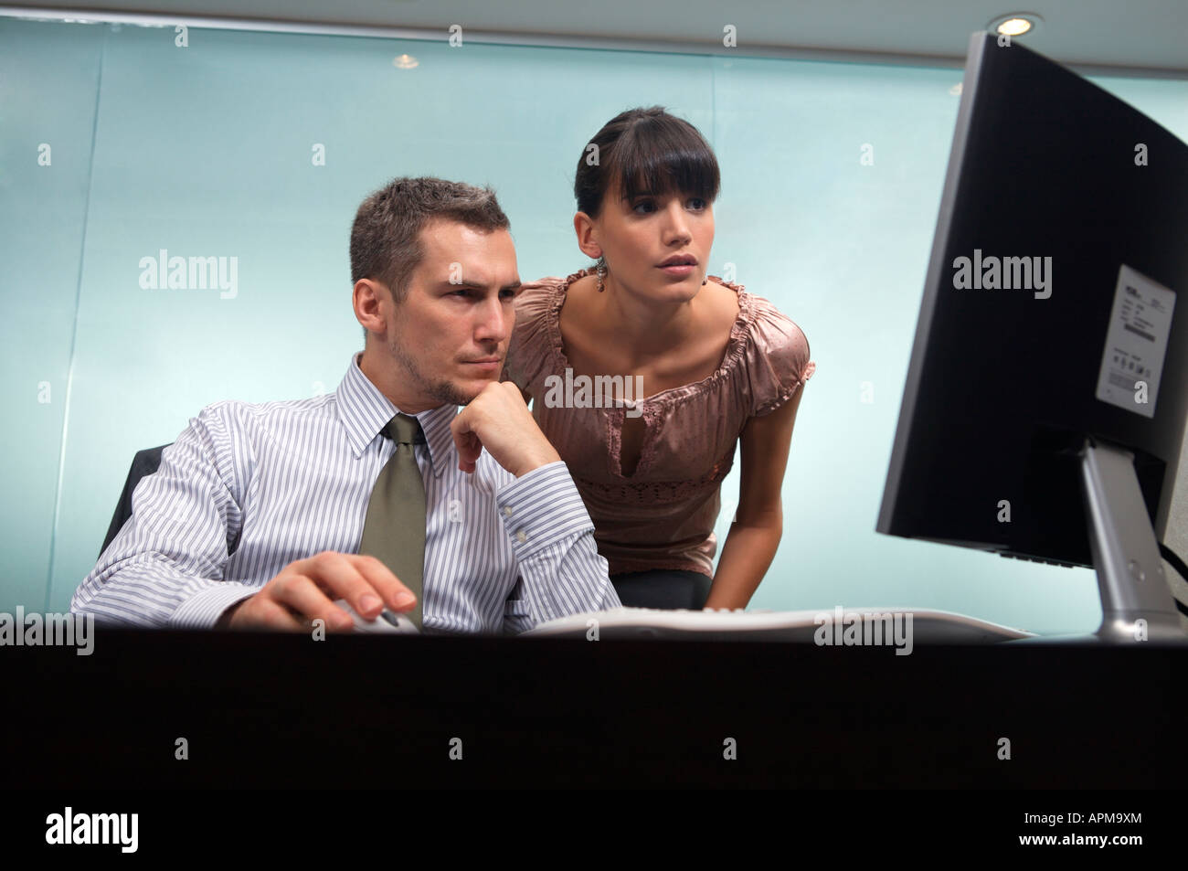 Business man and woman talking next to a computer display Stock Photo ...