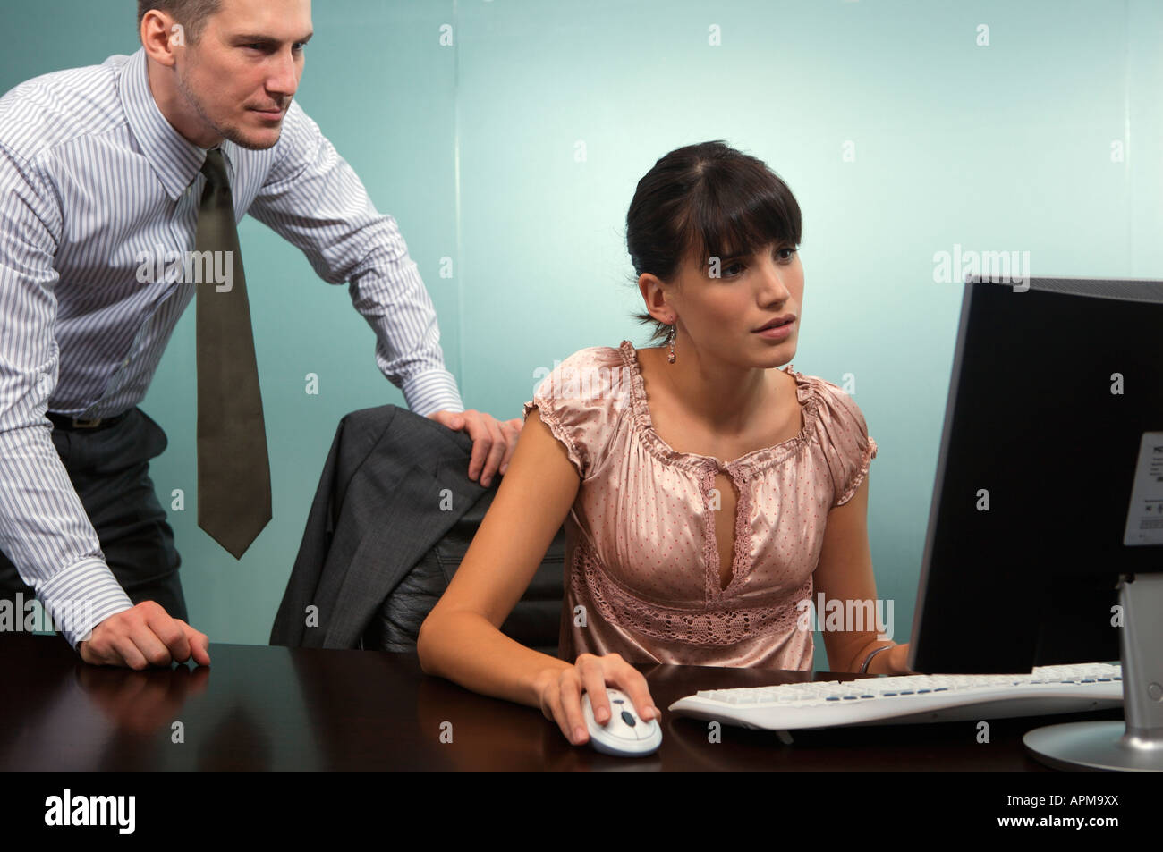 Business man and woman talking next to a computer display Stock Photo ...
