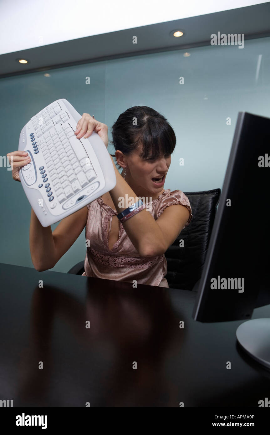 Angry business woman throwing computer keyboard Stock Photo - Alamy