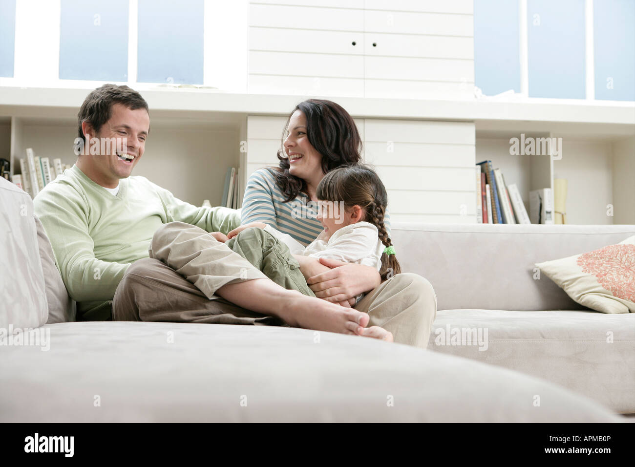 Parents and daughter talking on sofa Stock Photo - Alamy