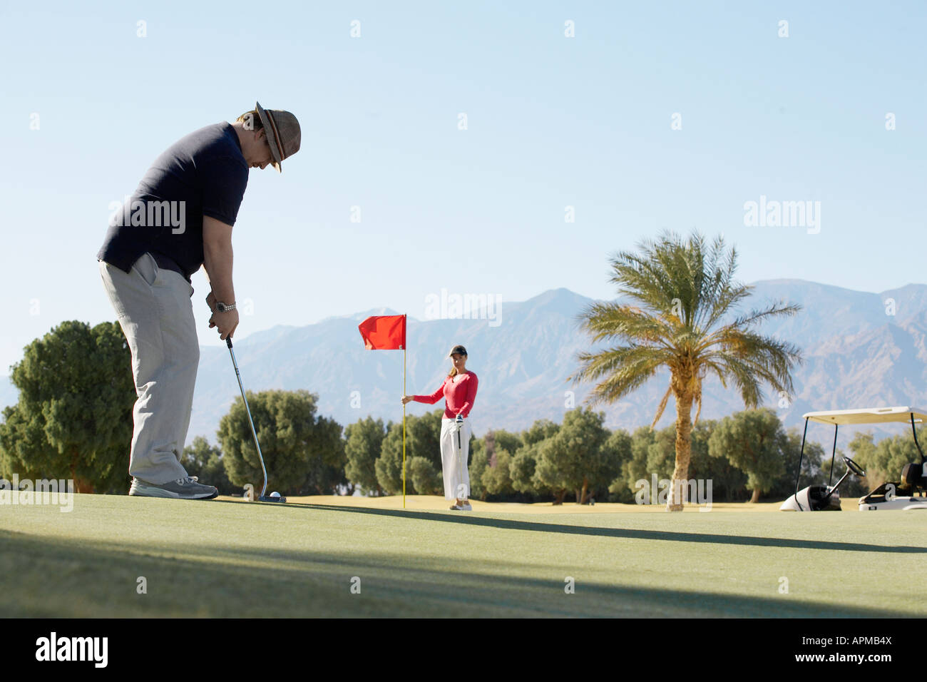 Two people playing golf at golf course Stock Photo - Alamy