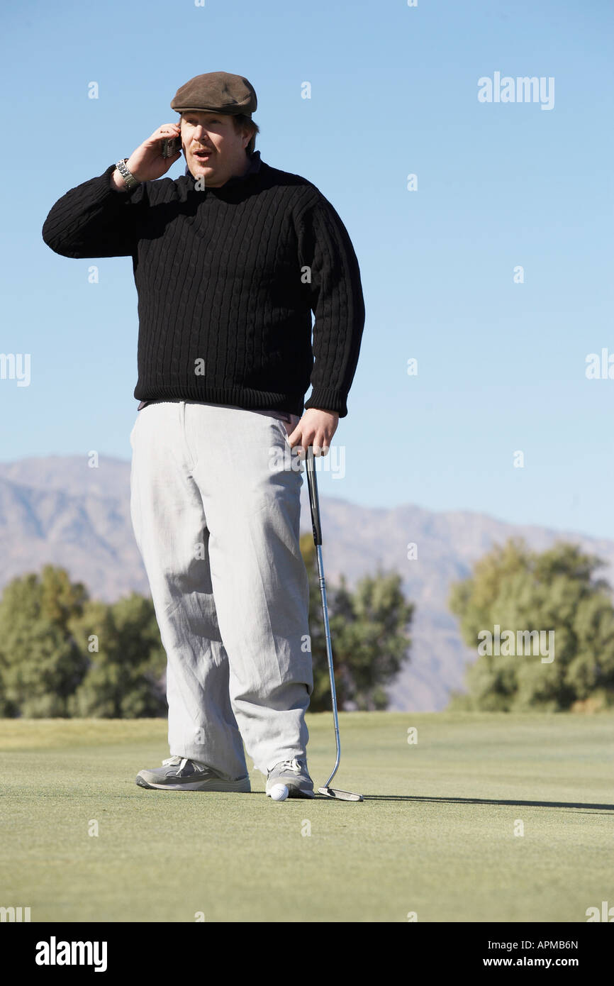 Man with golf club talking on phone Stock Photo - Alamy