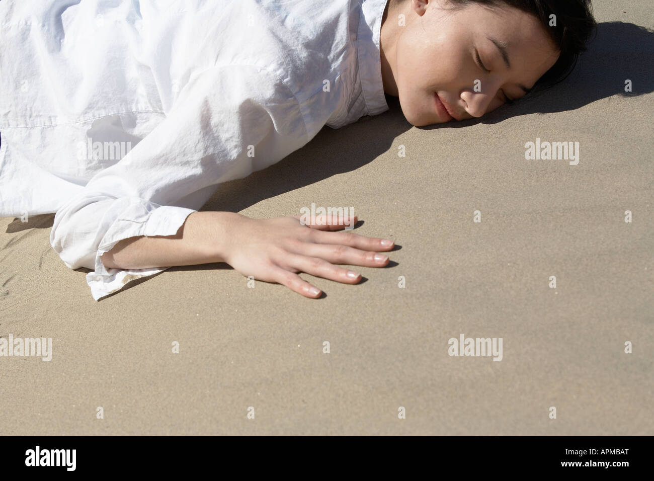 Young woman lying on sand Stock Photo - Alamy