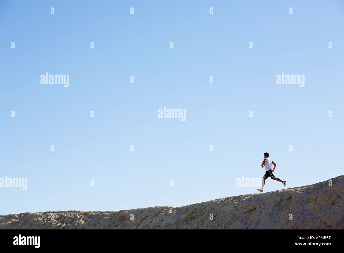 Man running on cliff Stock Photo - Alamy