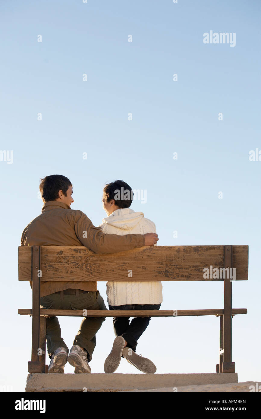 Young couple sitting on bench (rear view Stock Photo - Alamy
