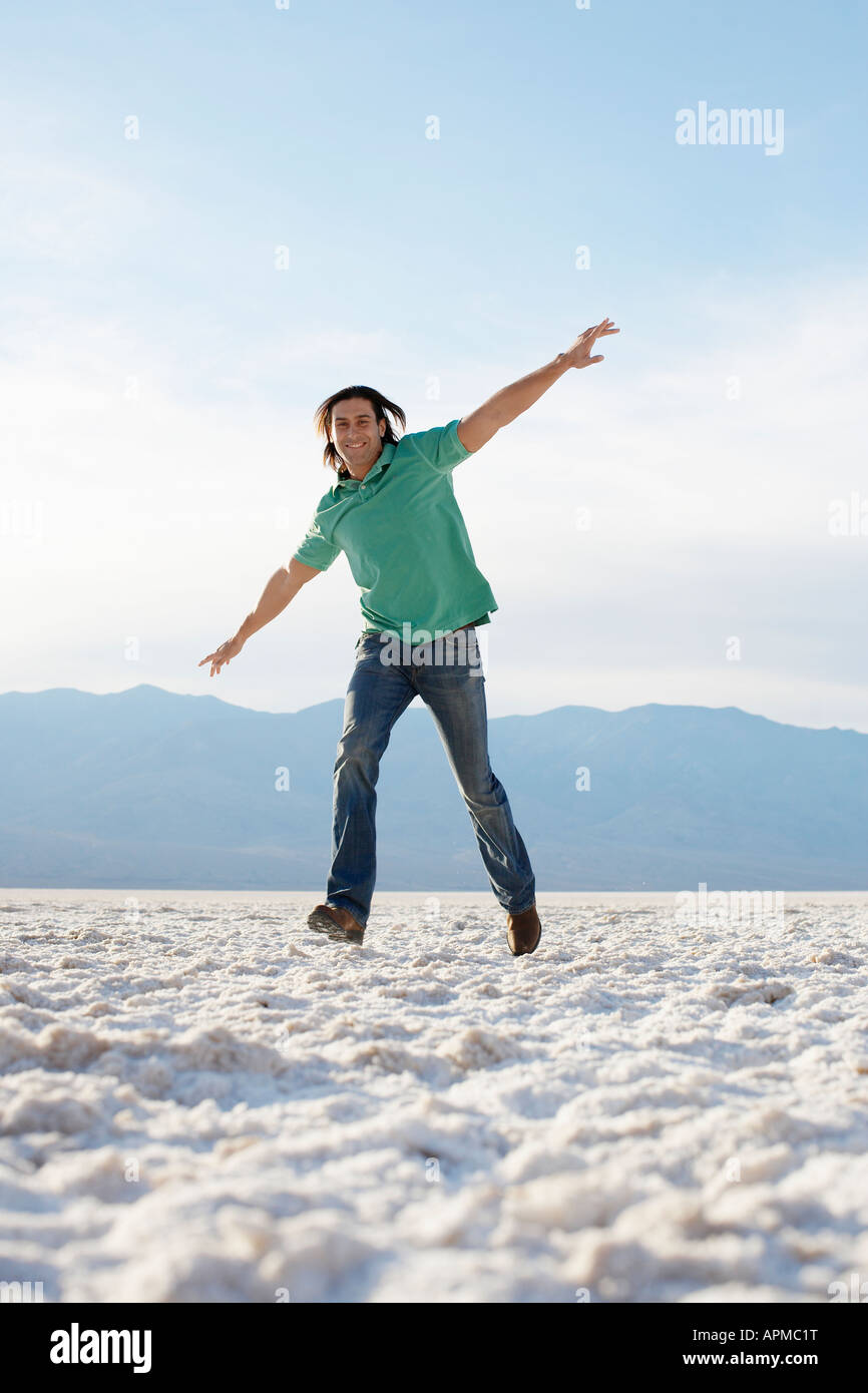 Mid adult man running with arms outstretched in desert Stock Photo - Alamy