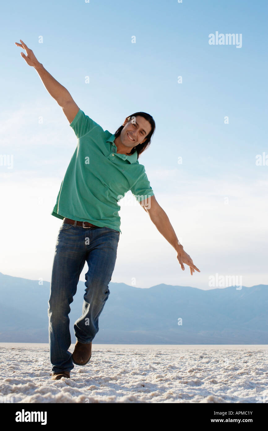 Mid adult man running with arms outstretched in desert Stock Photo - Alamy