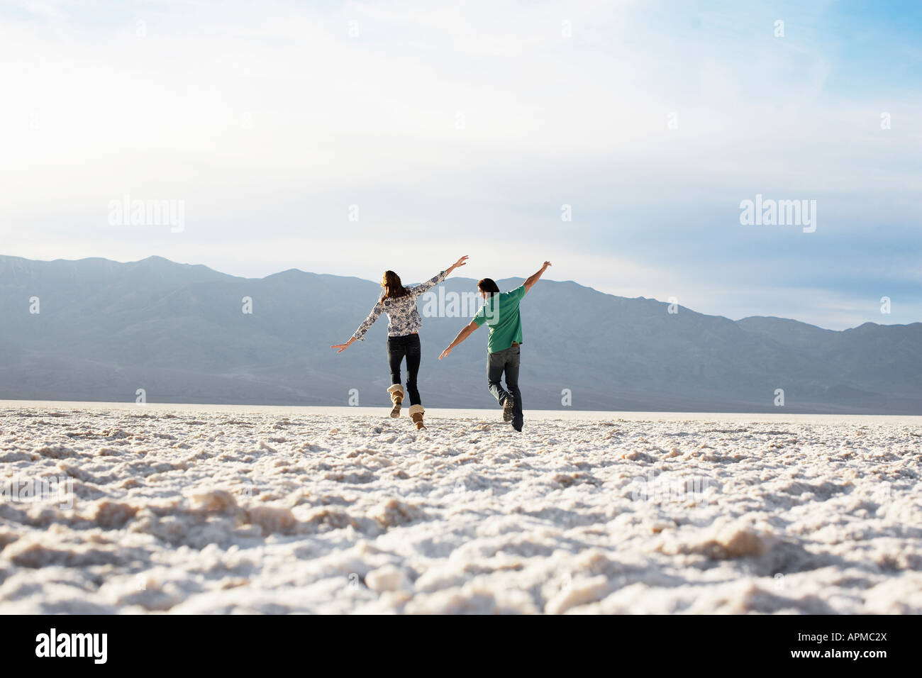 Woman and man running with arms outstretched Stock Photo - Alamy