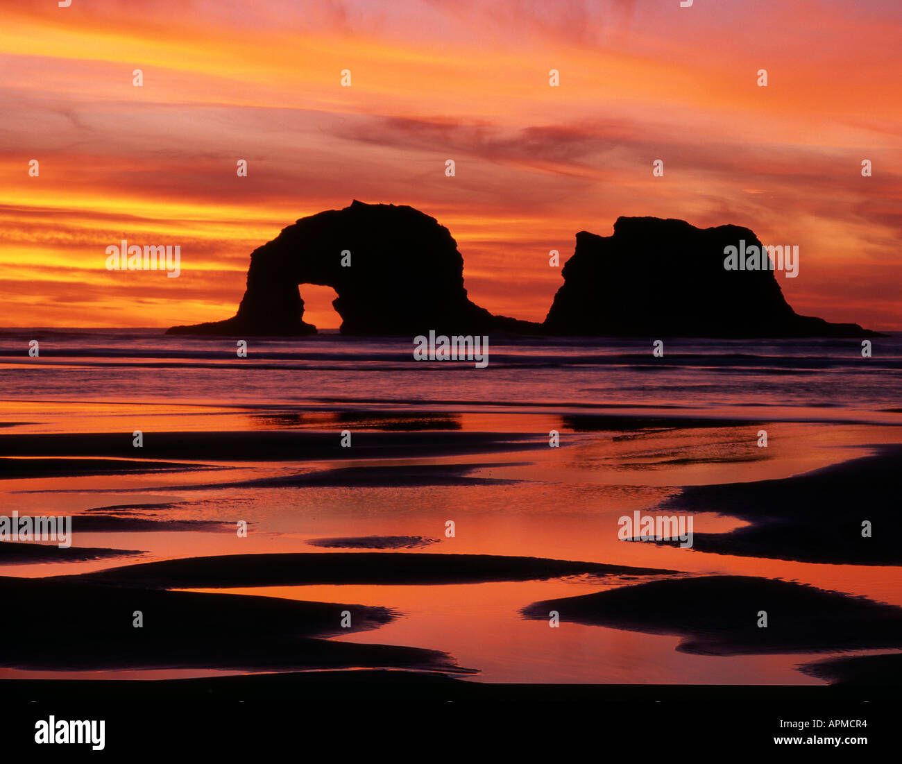 Sunset silhouettes the offshore sea stacks known as Twin Rocks on ...