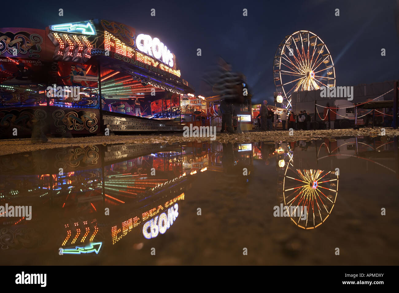 Fun fair and big wheel ride reflected in standing water at dusk Hull ...