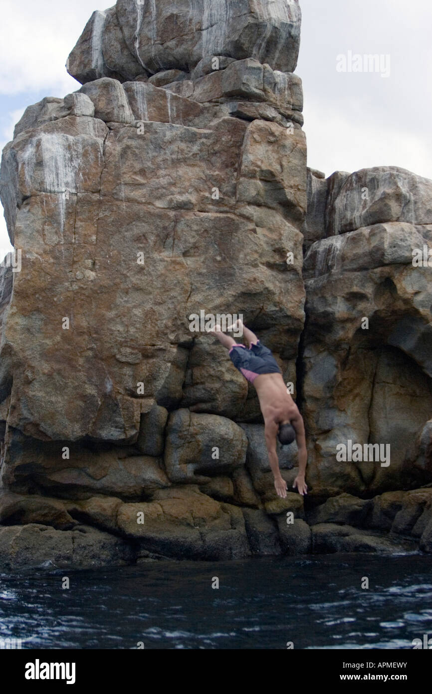 Young man high diving from rocks off Cabo San Lucas Baja California Sur ...