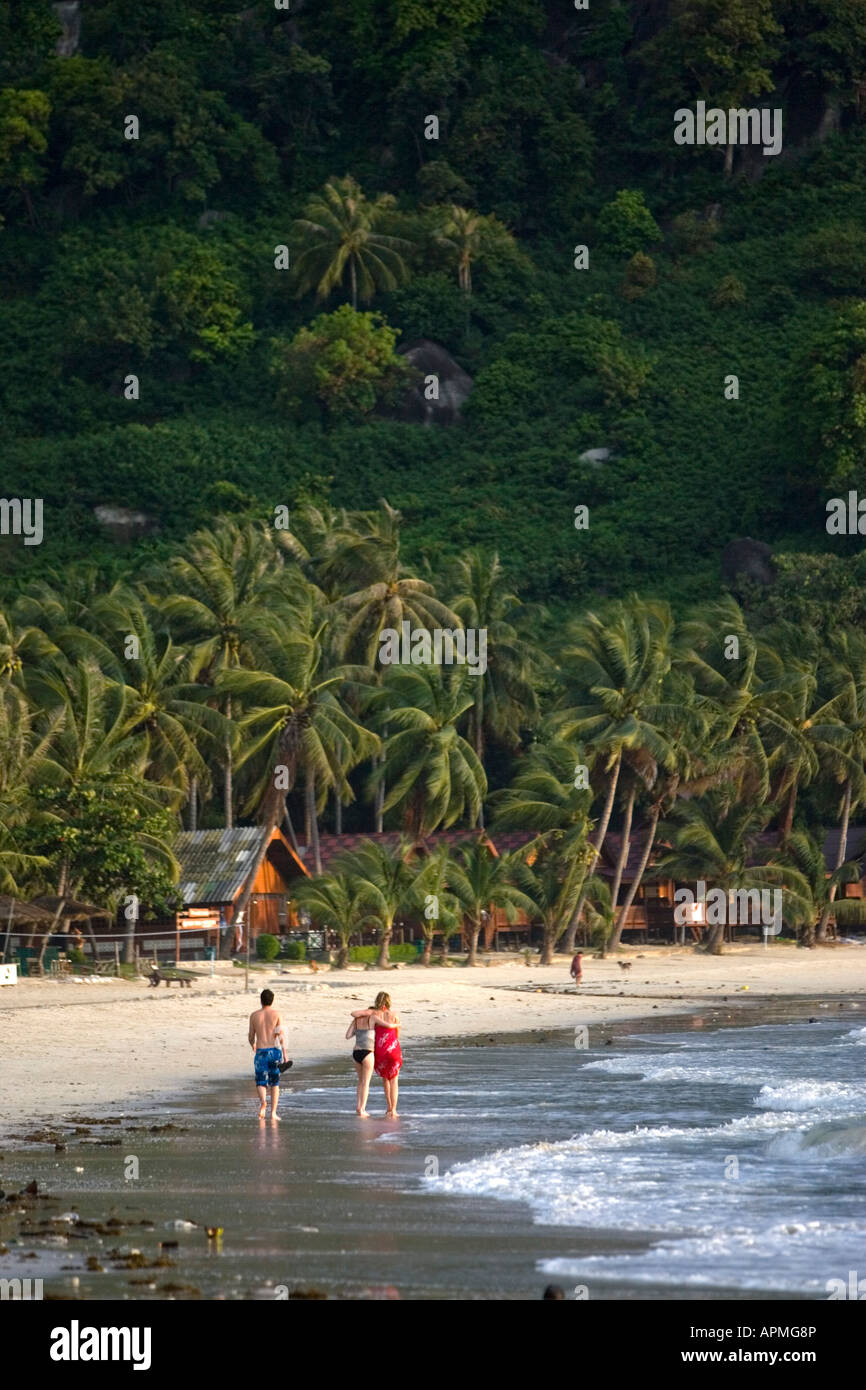 Young people walk in waves at water edge Hat Rin Nok Sunrise Beach Ko ...
