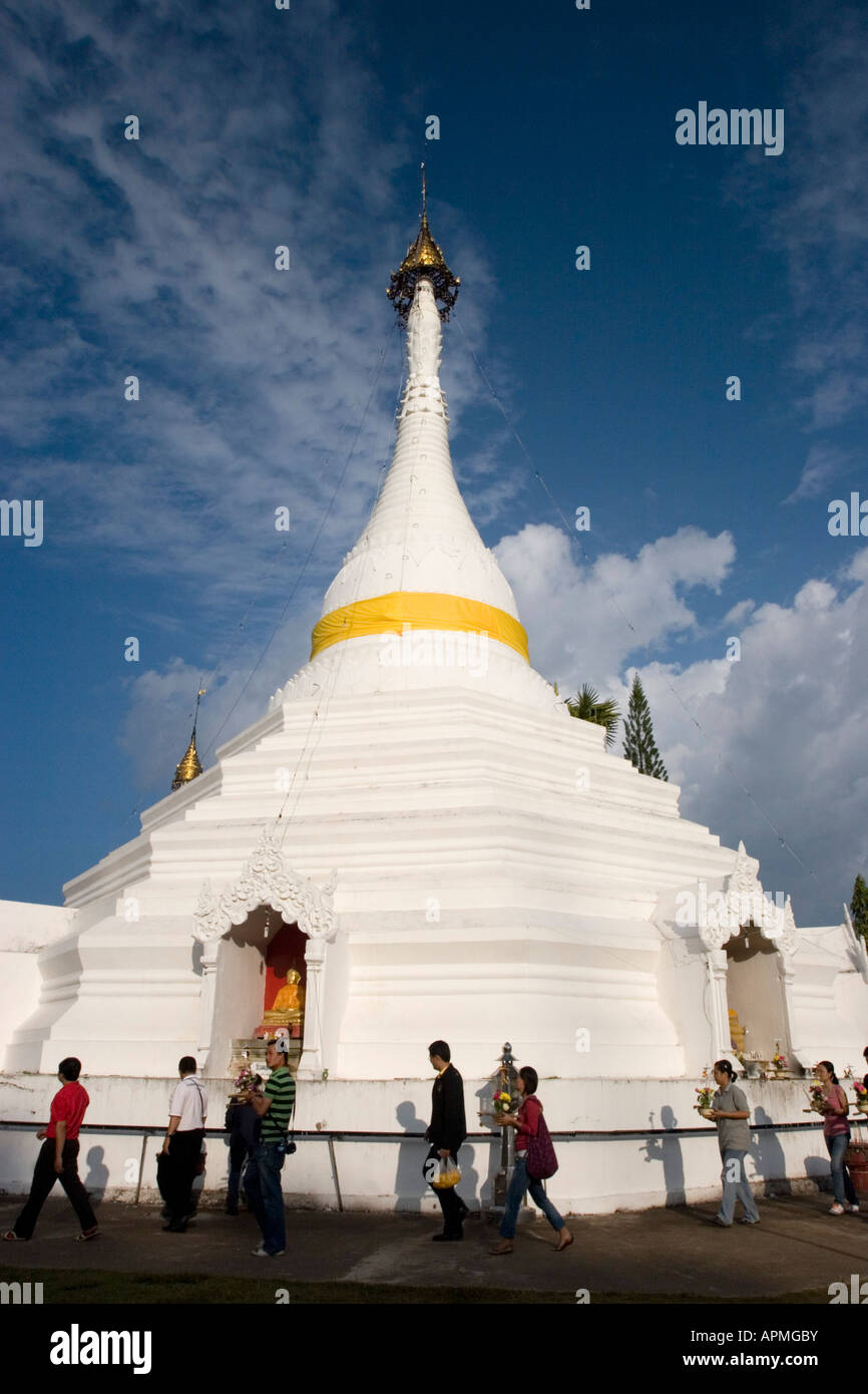 Buddhists carry ceremonial floats round hill top temple stupa during ...