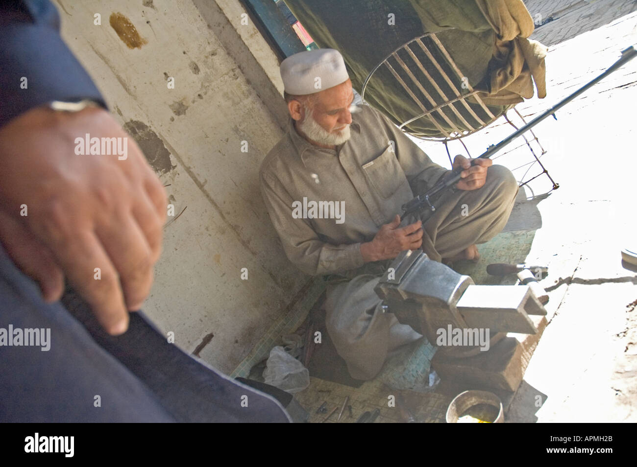 An old man at work polishing the barrel of a riffle in Darra Adam hel ...