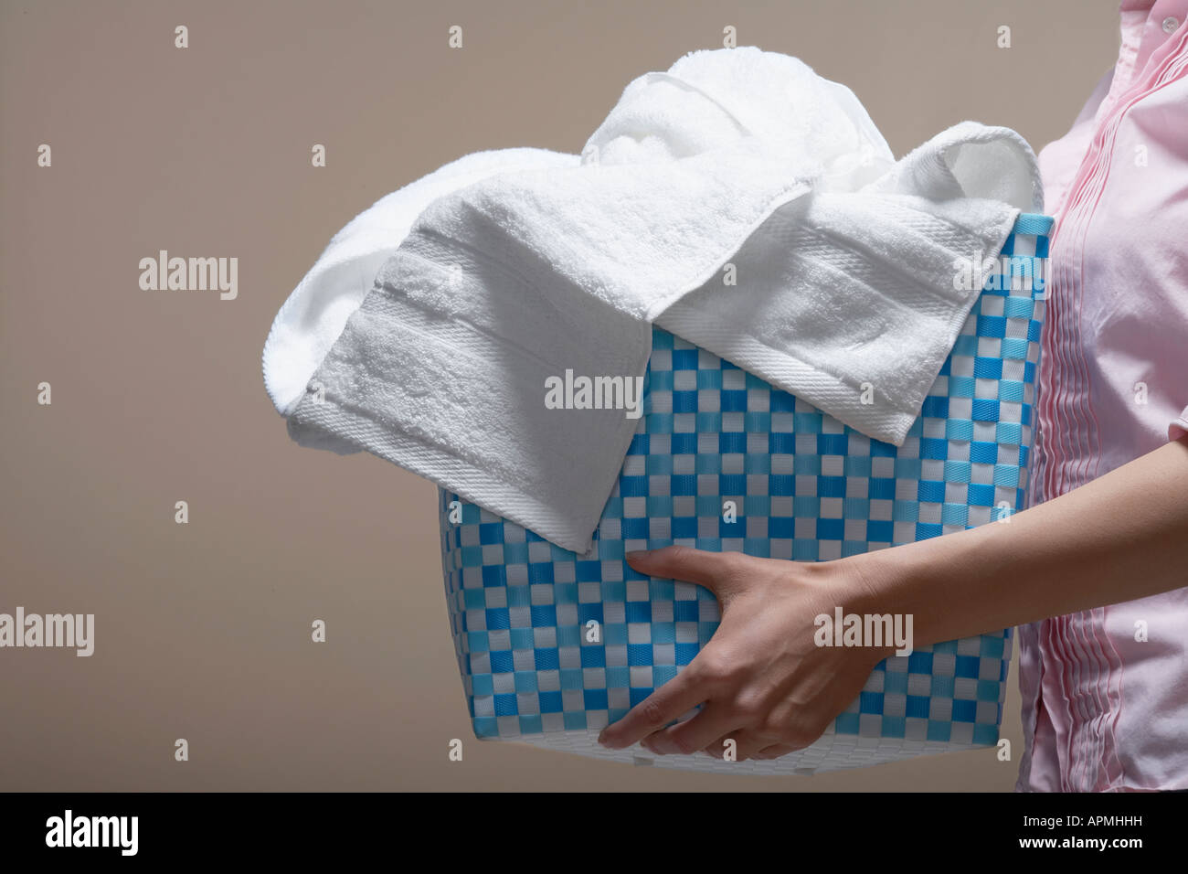 Young woman carrying laundry basket (midsection Stock Photo - Alamy