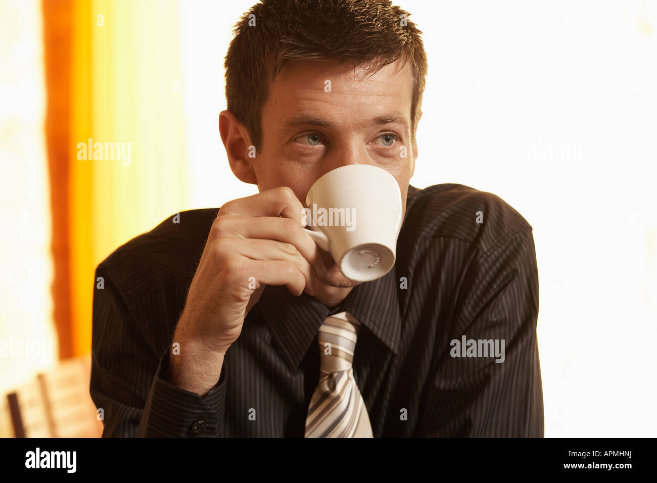Mid adult businessman drinking coffee Stock Photo - Alamy