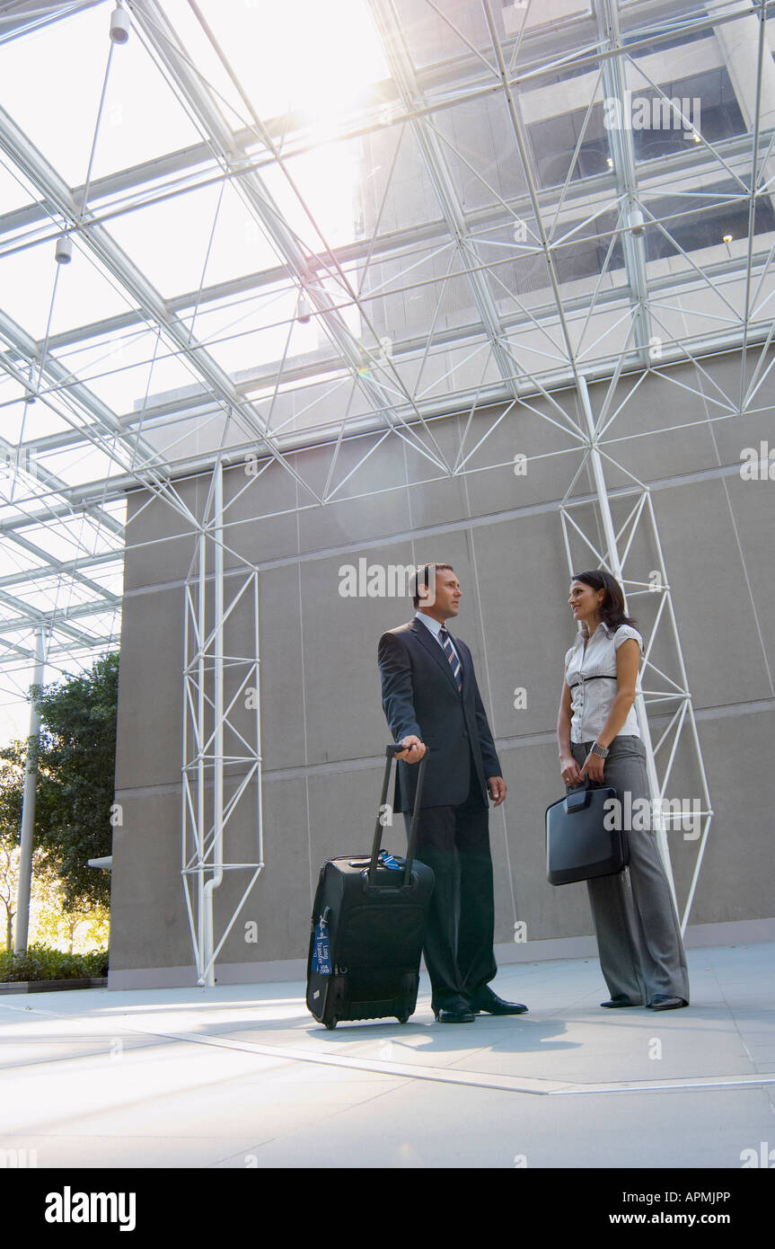 Two businesspeople talking in lobby (low angle view Stock Photo - Alamy