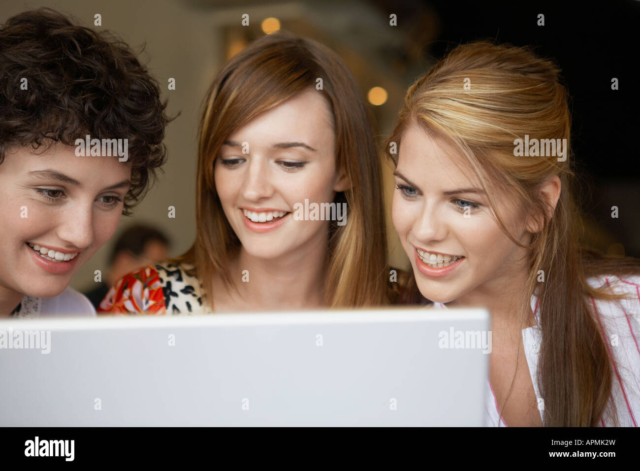 Three teenage girls using laptop Stock Photo - Alamy
