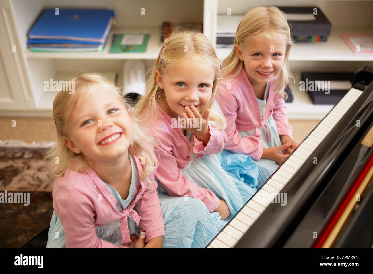 Triplets playing piano (high angle view Stock Photo - Alamy