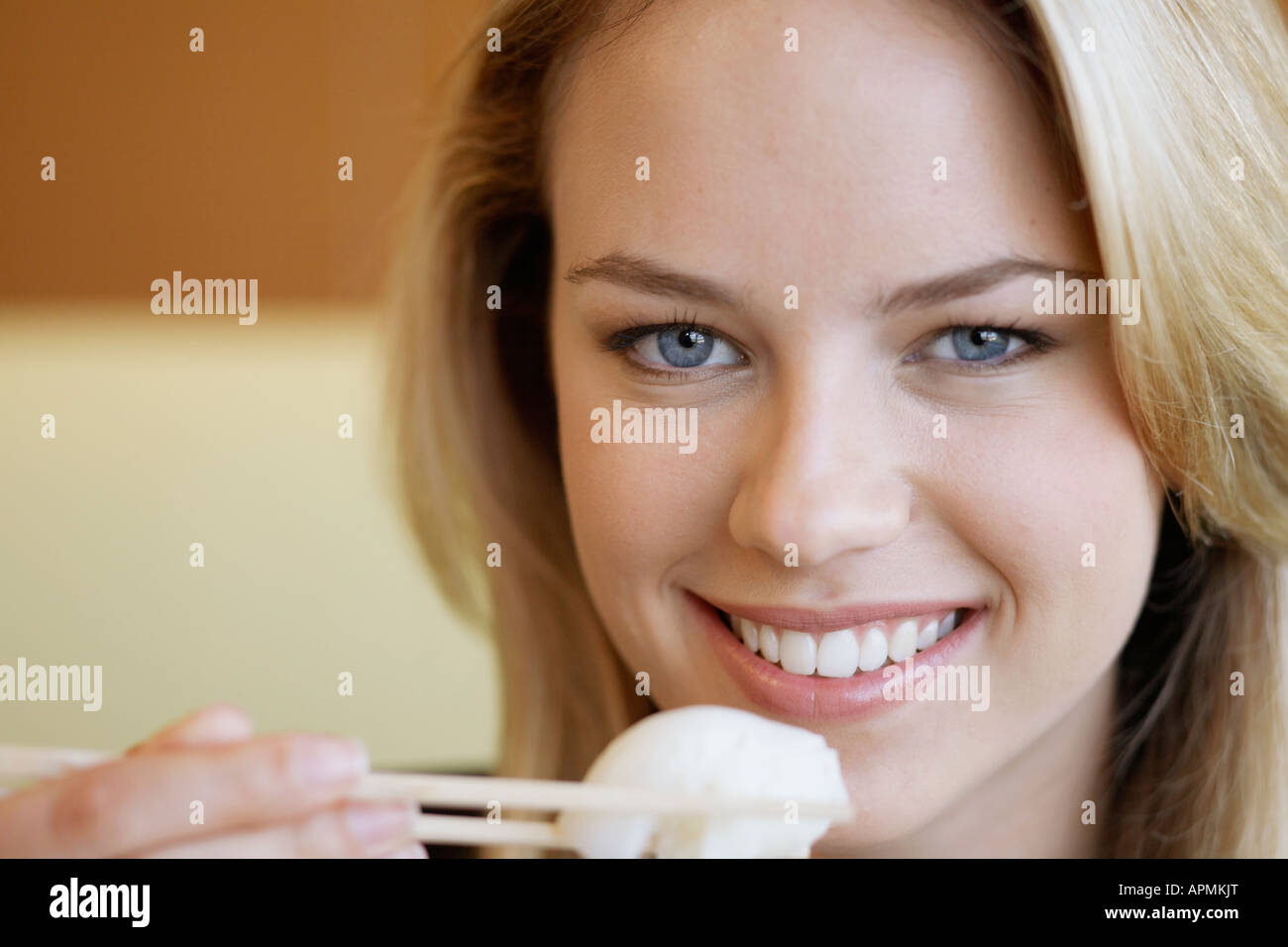 Young woman eating with chopsticks Stock Photo - Alamy