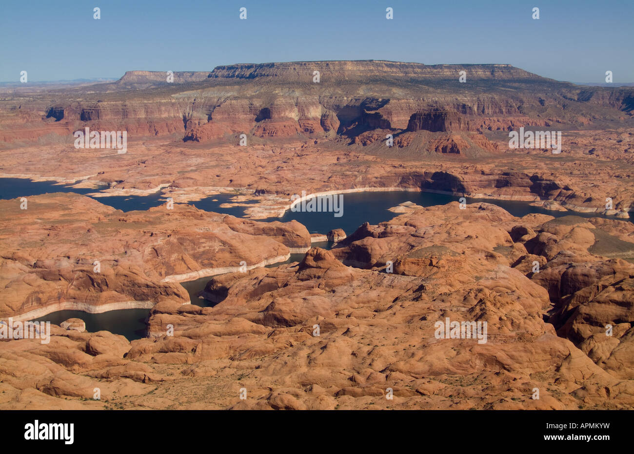 Aerial from above plane of Lake Powell area with tan desert and lake ...
