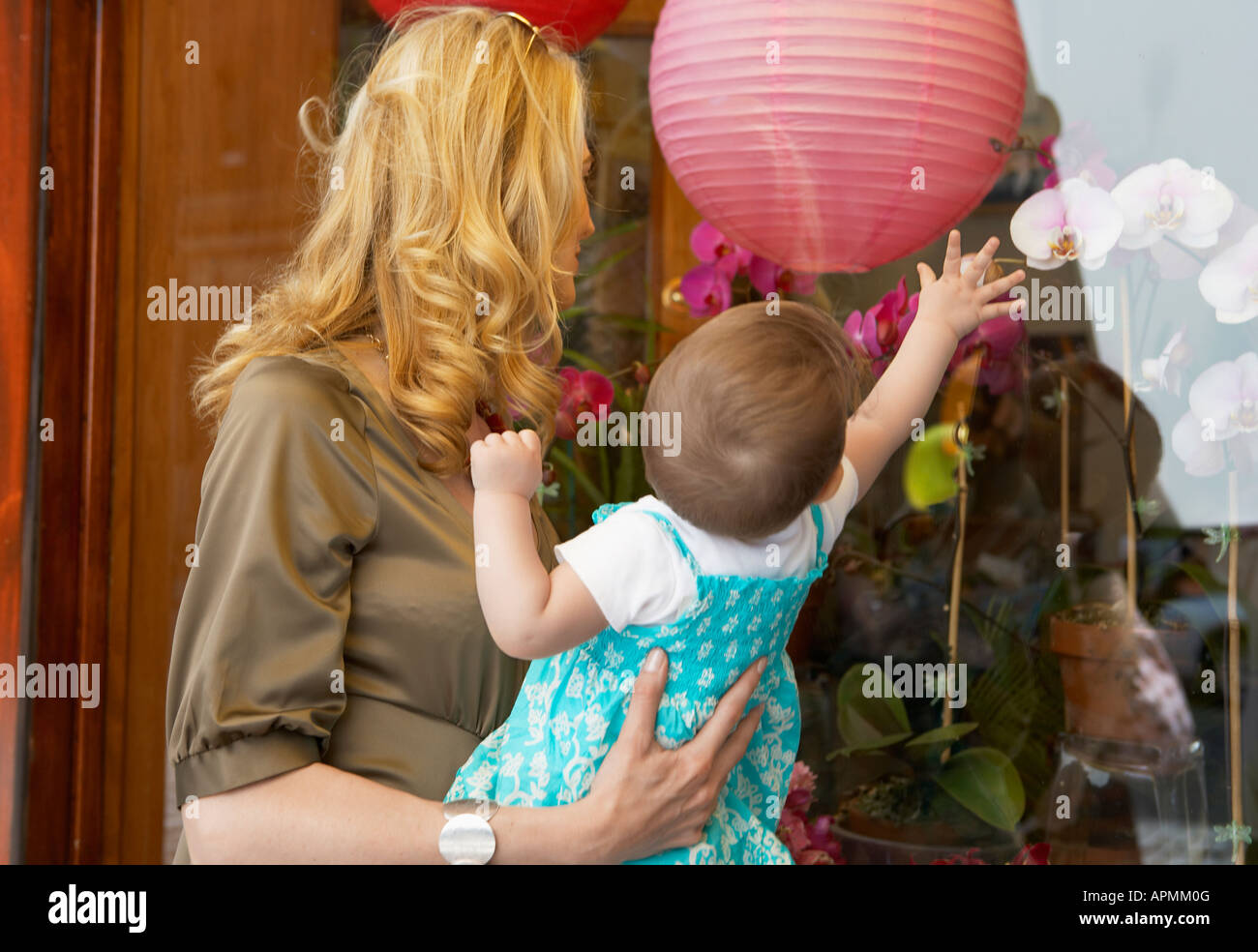 Mother with baby girl looking at window display Stock Photo - Alamy