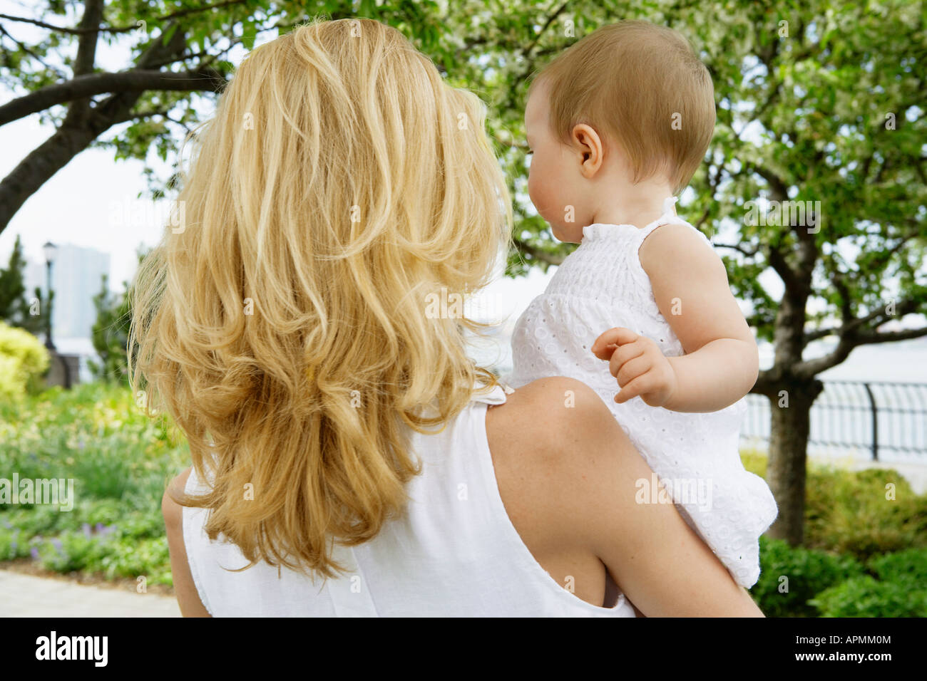 Mother carrying baby girl (rear view Stock Photo - Alamy