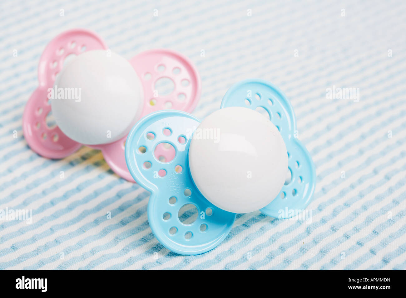 Pink and blue pacifiers Stock Photo - Alamy