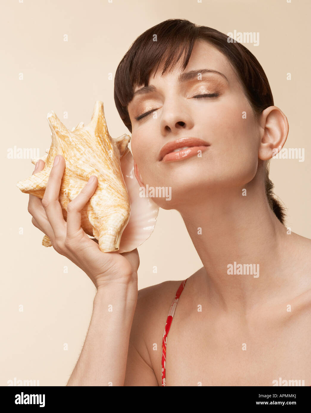 Woman holding conch shell ear hi-res stock photography and images - Alamy