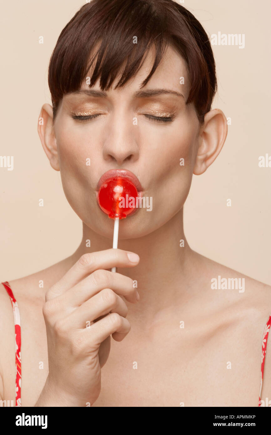 Mid adult woman eating lollipop Stock Photo - Alamy