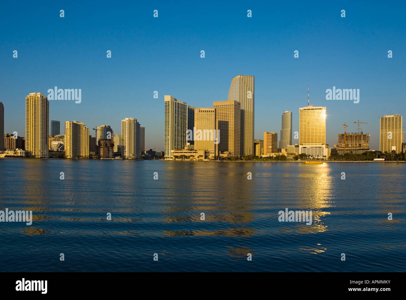 Golden rising sun reflects from high rise office buildings and reflects ...
