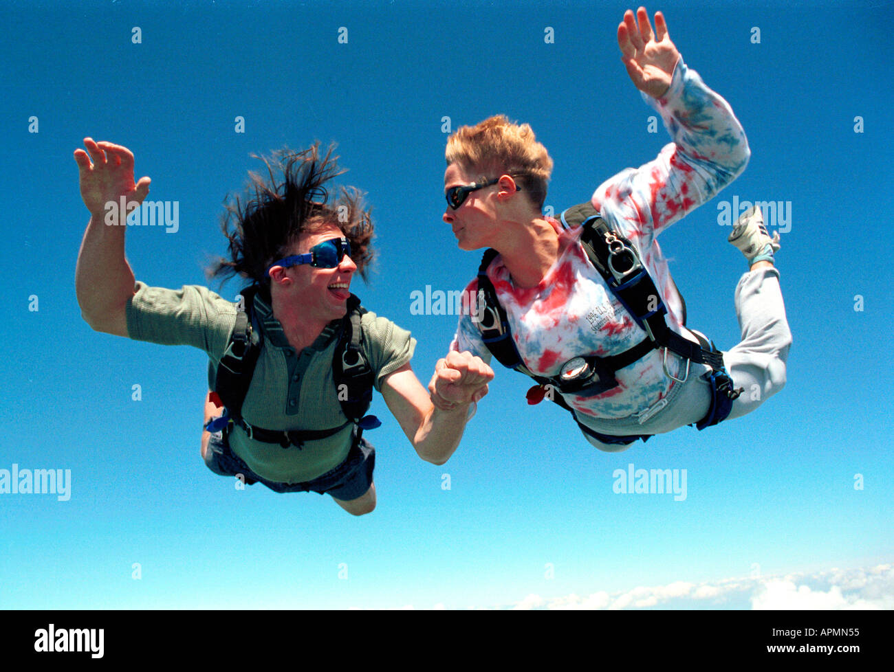 Two skydivers holding hands in freefall Stock Photo - Alamy
