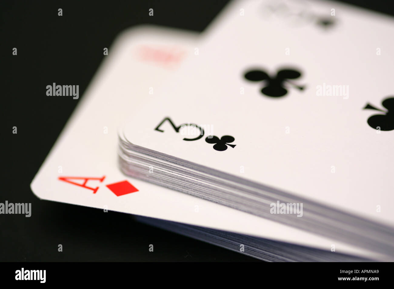 Bright red Ace of Diamonds playing card sticks out of a neat deck of ...