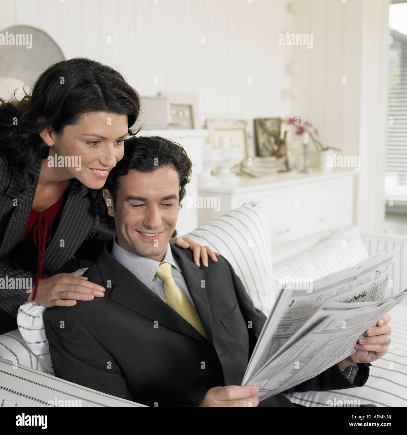 Mid adult couple reading newspaper Stock Photo - Alamy