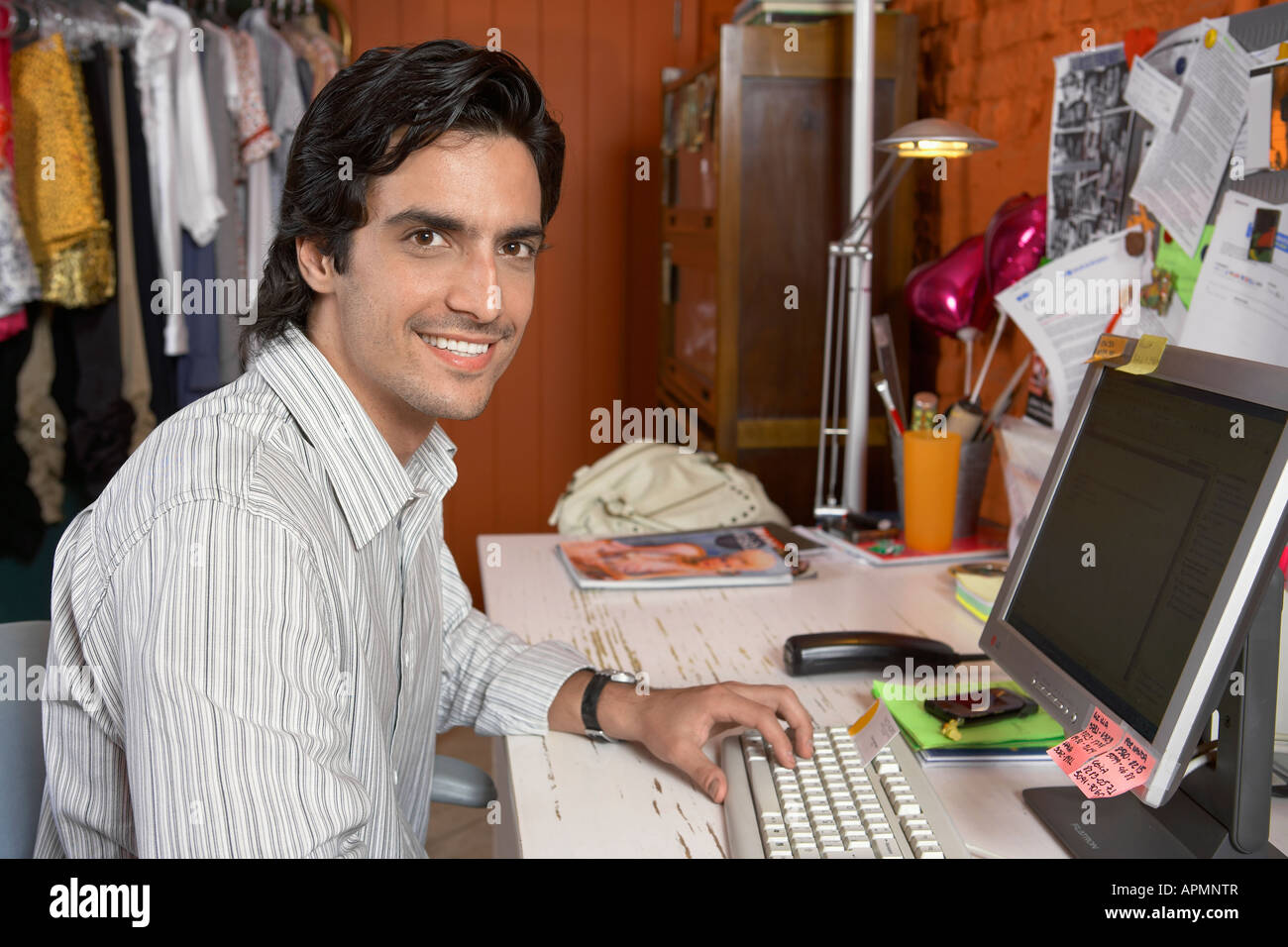 Clothes store owner using computer (portrait Stock Photo - Alamy