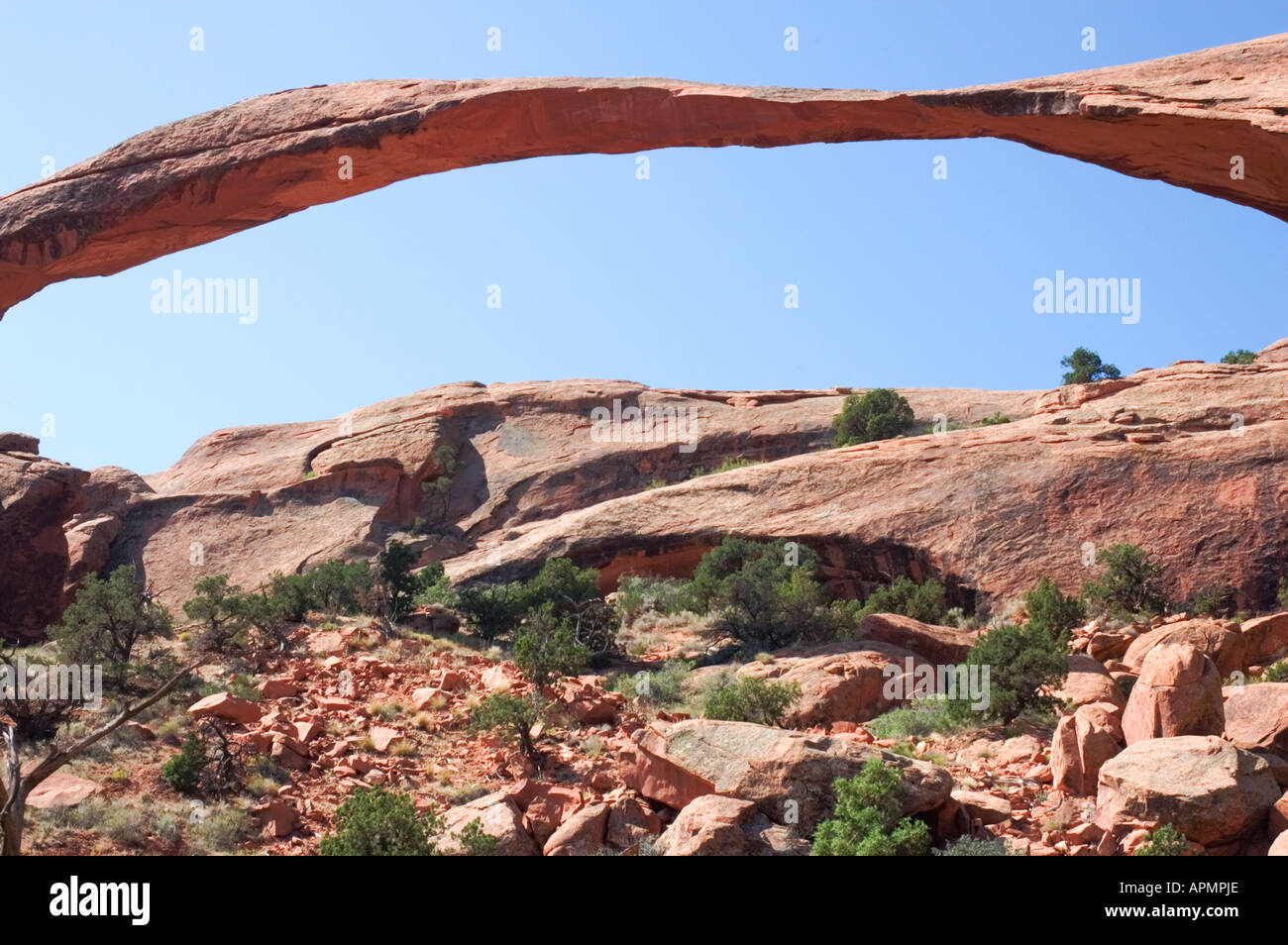The thin, orange sandstone span of Landscape Arch stretches across a ...