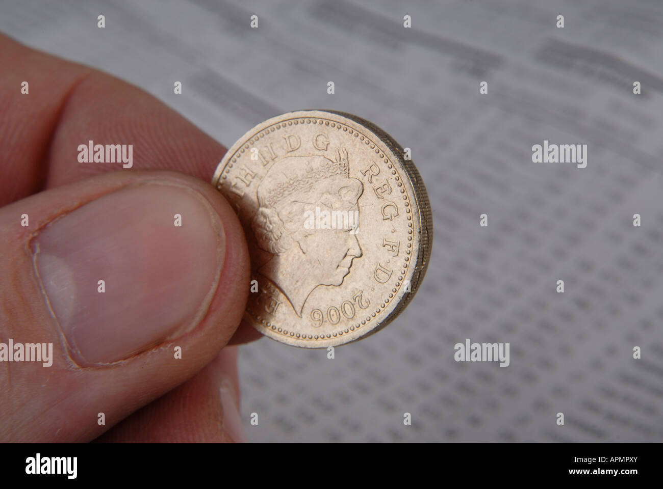 Coin held in fingers Stock Photo - Alamy