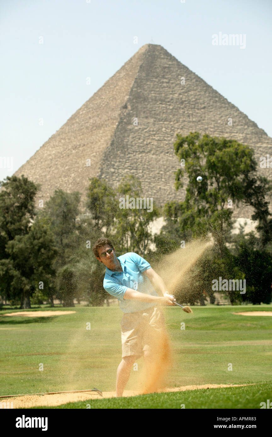 Man playing golf from bunker with pyramid behind, Egypt Stock Photo - Alamy