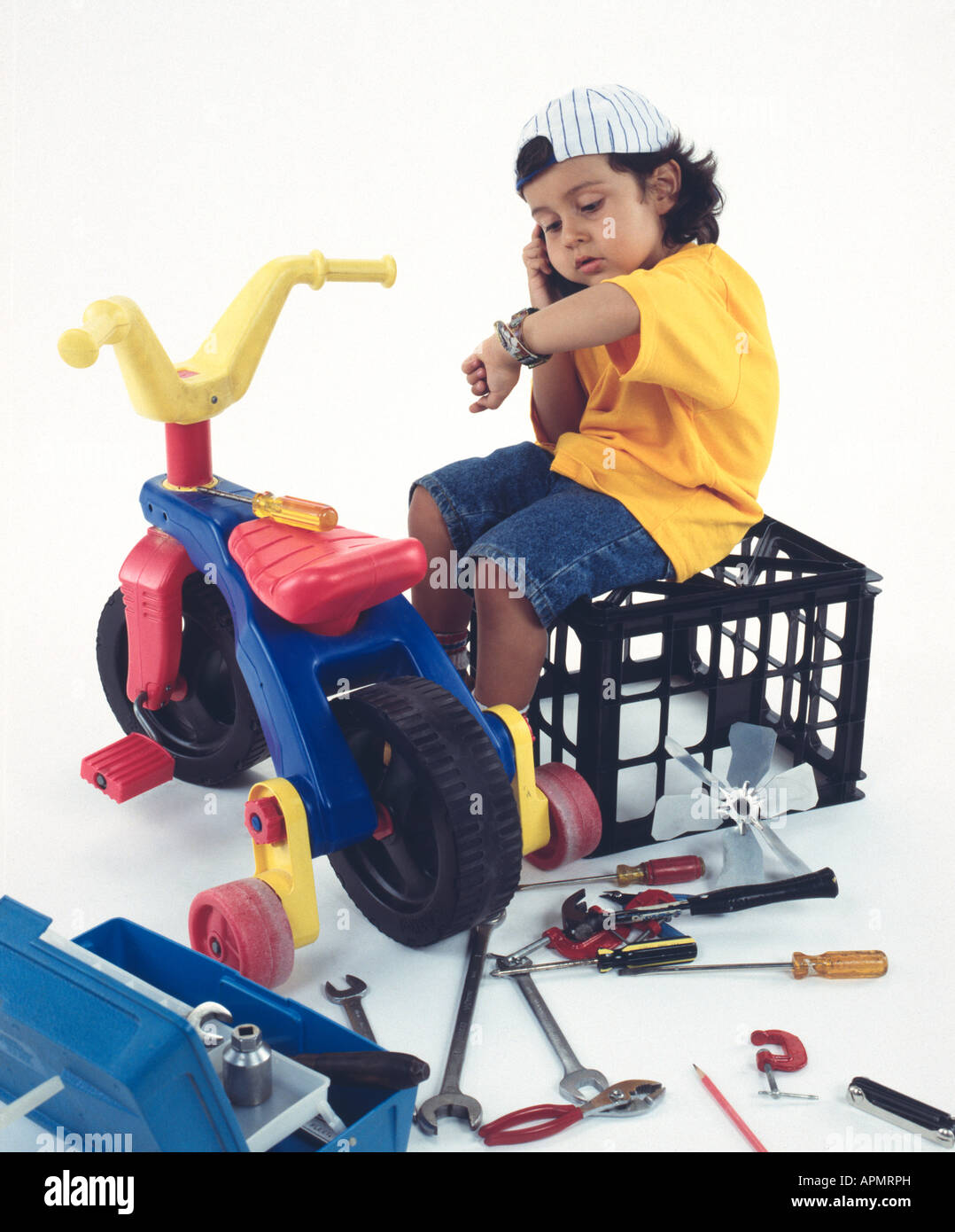 A little boy pretends to be a mechanic fixing his bike with tools all ...